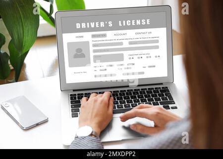Woman filling in driver's license form online on website using laptop ...