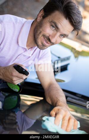 Taking care of washing. Man is with his car outdoors Stock Photo - Alamy