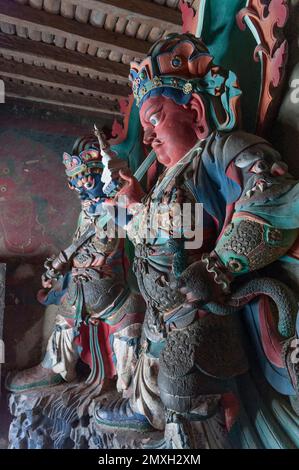 Brightly coloured statues of Tibetan deities inside the Buddhist Kumbum ...