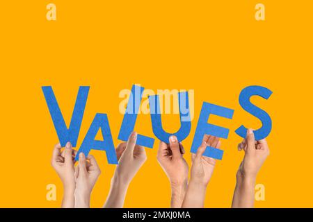 People making word VALUES of letters on yellow background Stock Photo ...