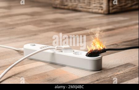 Inflamed plug in power board - result of electrical short circuit Stock ...