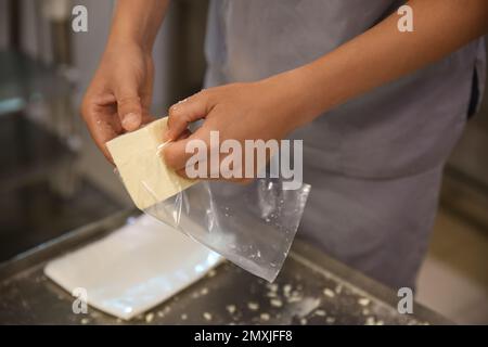 Worker packaging feta cheese at modern factory, closeup Stock Photo - Alamy