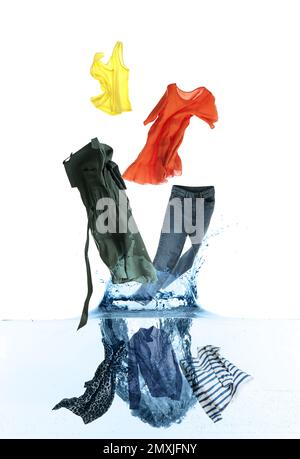 Different clothes falling into water against white background Stock ...