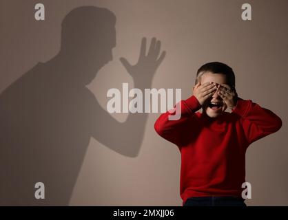 Child abuse. Father yelling at his son. Shadow of man on wall Stock ...