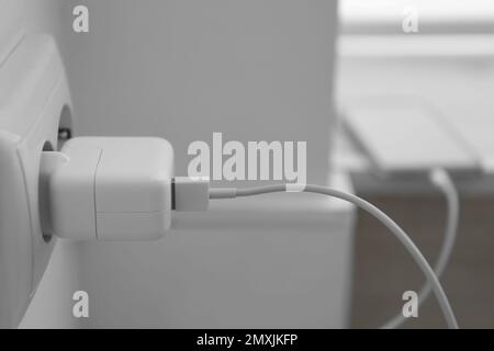 Modern smartphone charging from electric socket indoors Stock Photo - Alamy