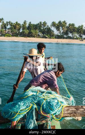 A male rowing a canoe boat near the seaside with trees on the horizon ...