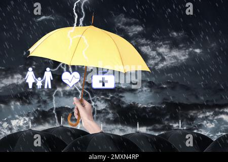 Insurance agent covering illustrations with yellow umbrella during ...
