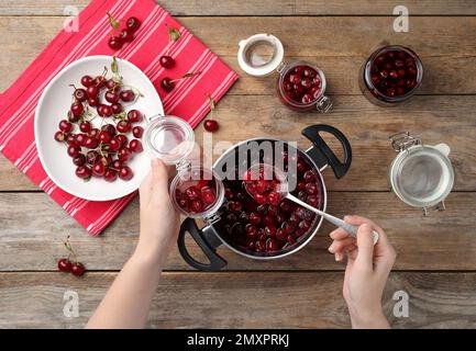 Top view of delicious sweet pickled fruit in plastic cup with wooden ...