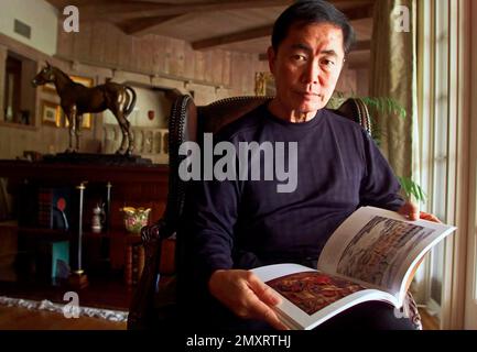 Actor George Takei looks at a book showing paintings of the Tule Lake ...