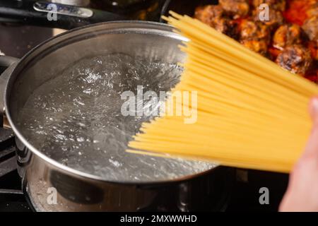 Dip spaghetti into boiling water in a saucepan. Pasta cooking Stock ...