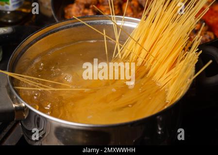 Dip spaghetti into boiling water in a saucepan. Pasta cooking Stock ...