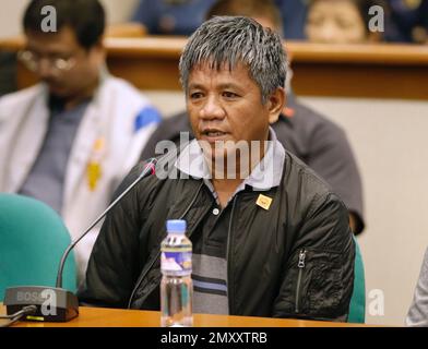Former Filipino militiaman Edgar Matobato, center, walks under tight ...