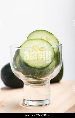 One juicy smooth cucumber on a wooden cutting board, macro isolated on ...