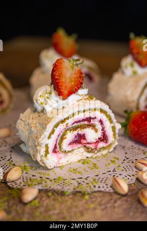 Meringue roll with strawberries on a white table near the basket Stock ...