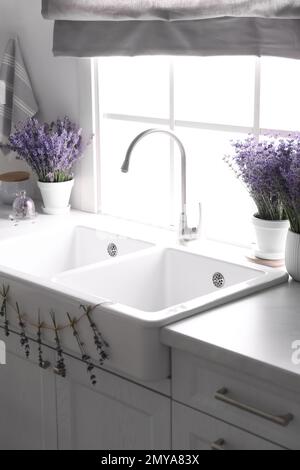 Beautiful lavender flowers on countertop near sink in kitchen Stock ...