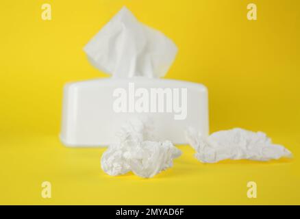 Used paper tissues and white holder on light blue background, closeup ...