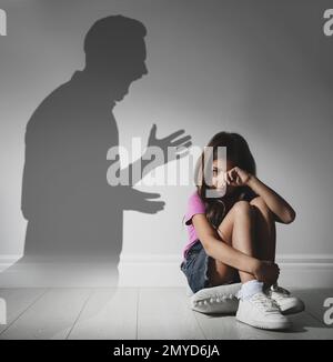 Child abuse. Father yelling at his daughter. Shadow of man on brick ...