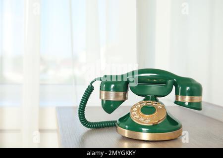 Vintage corded phone on wooden table against black background Stock ...
