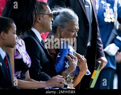 Nola Whitfield, wife of 2nd Lt. Malvin G. Whitfield, hugs the U.S. flag ...