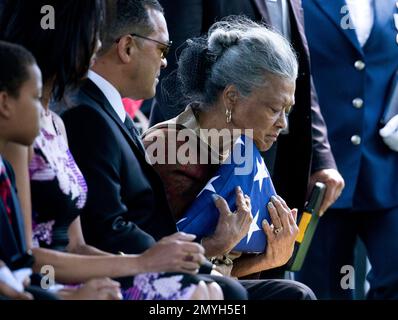 Nola Whitfield, wife of 2nd Lt. Malvin G. Whitfield, hugs the U.S. flag ...
