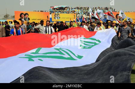 Supporters of the Supreme Islamic Iraqi Council wave Iraqi national ...