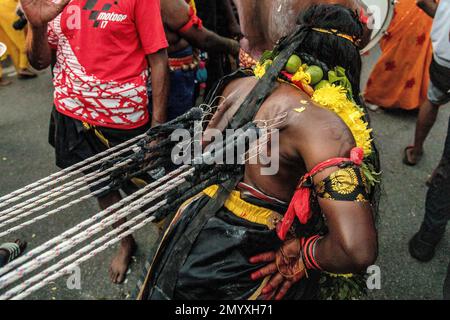 A Hindu devotee makes her way back through a narrow ledge on the banks ...