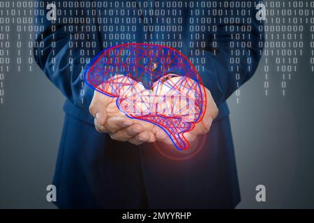 Businessman demonstrating digital image of brain on dark background ...