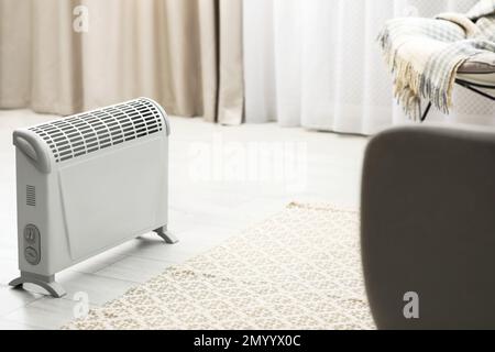 Modern electric heater in stylish room interior Stock Photo - Alamy