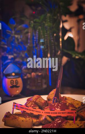 Potato dressed as a policeman in front of a plate with potato wedges ...