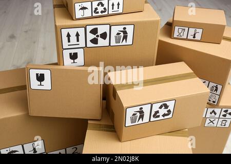 Cardboard boxes with different packaging symbols on floor. Parcel ...