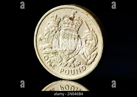 A worn 2015 UK £1 coin featuring the Coat of Arms on the reverse side ...
