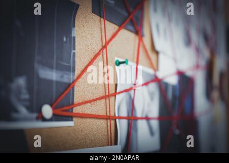 Detective board with crime scene photos, stickers, clues and red thread ...