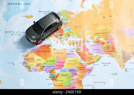 Grey toy car on world map. Trip planning Stock Photo - Alamy