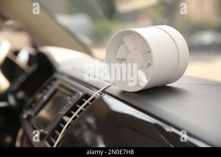 Portable fan on dashboard in car. Summer heat Stock Photo - Alamy