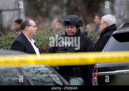 Investigators work the scene at one of the residences, center, where ...