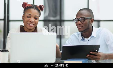 Smiling group of diverse businesspeople going over paperwork together ...