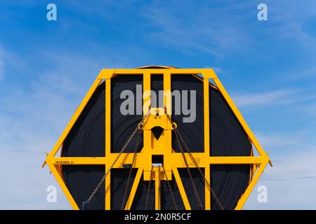 Steel coil shipment in a yellow container with support chains attached ...