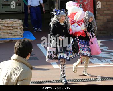 Two women clad in "Lolita" costumes walk in Tokyo, Monday, Dec. 7, 2015 ...