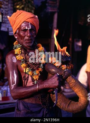A devotee holding fire torch, discharging vow in Ranganatha temple at ...