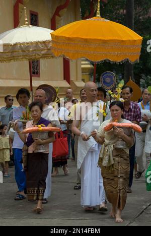 A Buddhist novice monk walking around the white stupa in sunny day ...