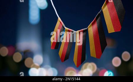 A garland of Germany national flags on an abstract blurred background ...