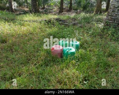colorful pesticide containers left at the oil palm plantation Stock ...