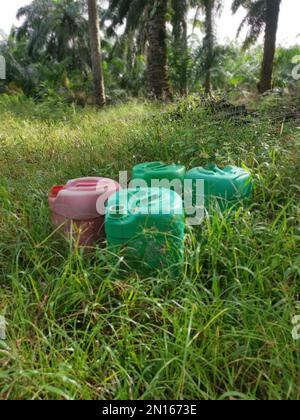 colorful pesticide containers left at the oil palm plantation Stock ...