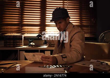 Old fashioned detective working at table in office. Black and white ...