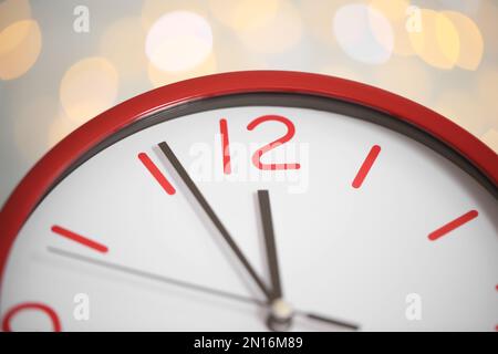 Clock showing five minutes until midnight on white background, closeup ...