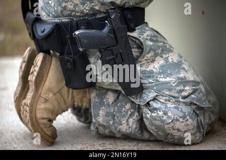 A member of the 139th Military Police Company shoots his 9mm Beretta M9 ...