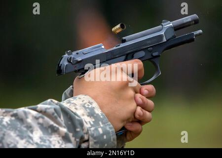 A 9mm case is ejected from the chamber of a Beretta M9 during a ...
