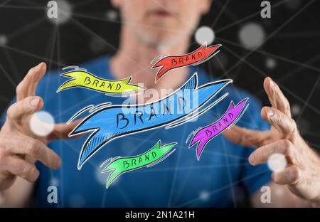 Brand concept between hands of a man in background Stock Photo - Alamy