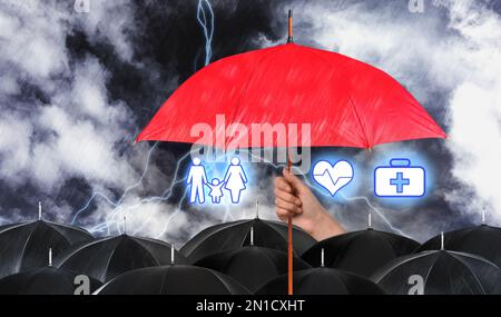 Insurance agent covering illustrations with red umbrella during storm ...