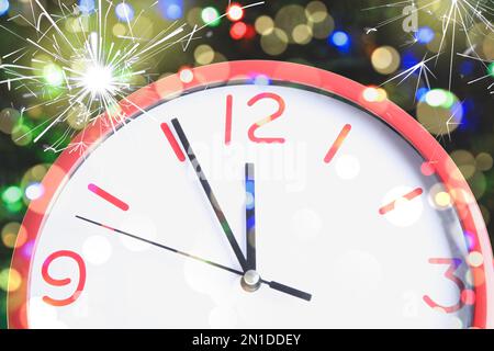 Clock showing five minutes till midnight with fir tree branches ...